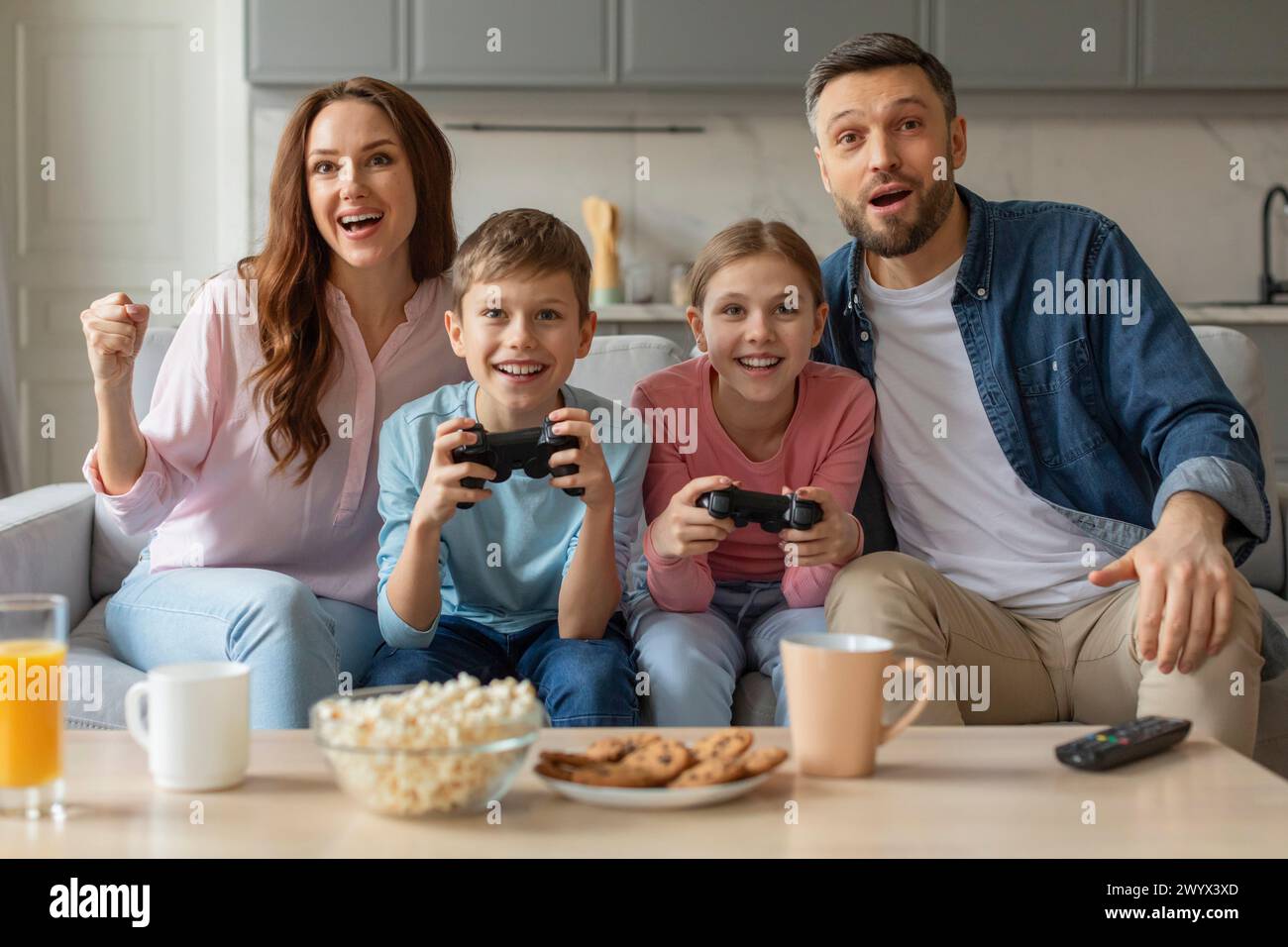 Family engaged in an intense video game session Stock Photo - Alamy