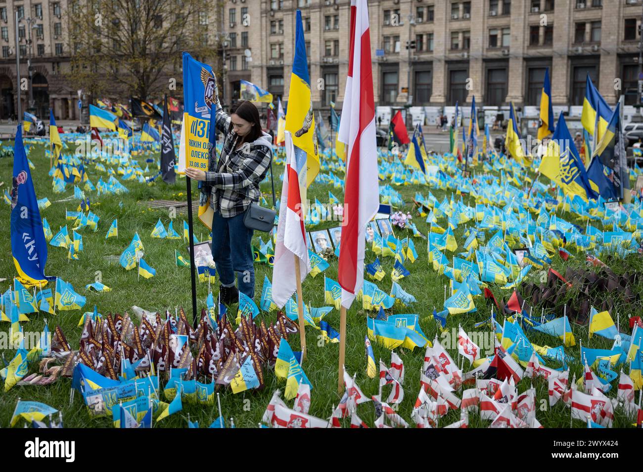 A girl straightens the flag at an improvised memorial site on ...
