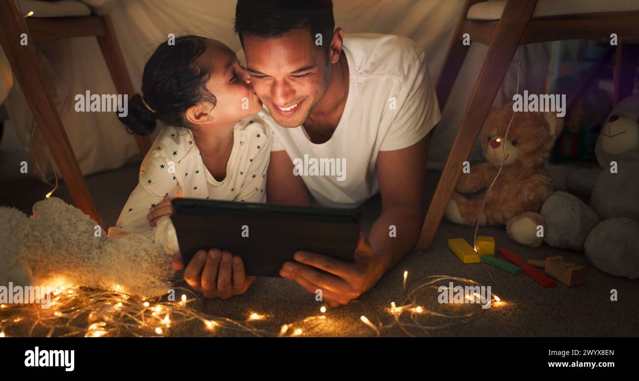 Happy, tablet and child kiss father in a tent house streaming internet ...