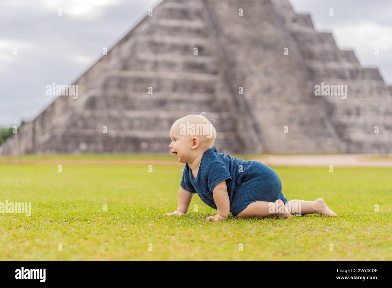 Baby traveler, tourists observing the old pyramid and temple of the ...