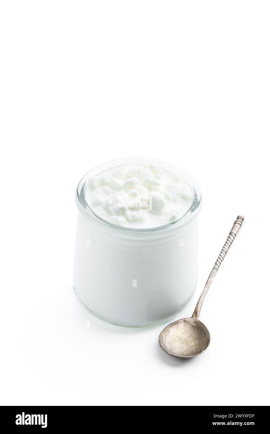 Granular cottage cheese with cream in a glass jar isolated on white ...