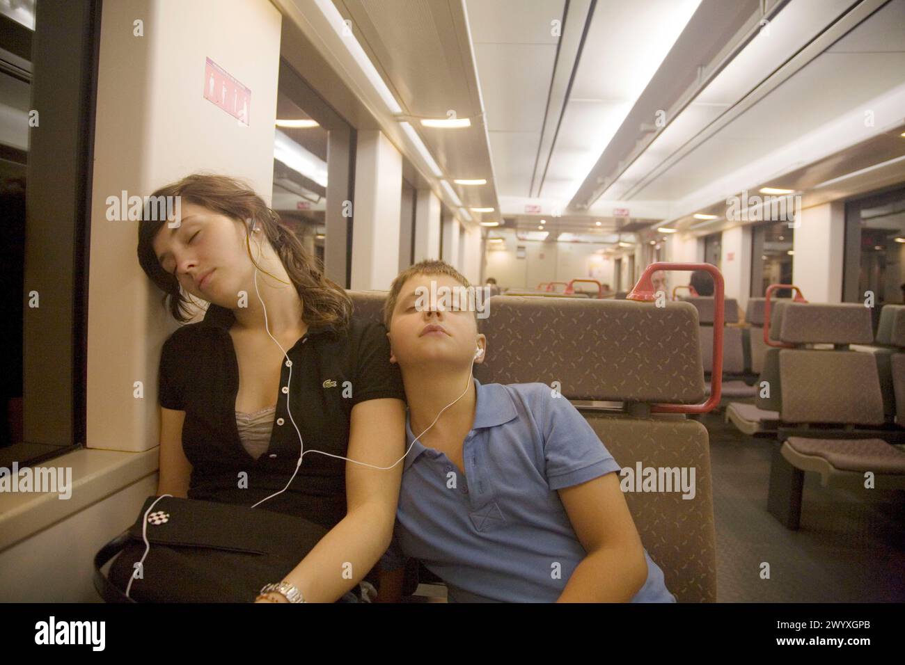 10 and 18 year old brother and sister in commuter train using iPod ...