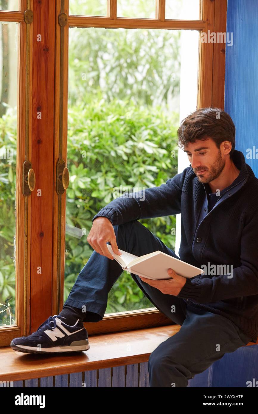 Man reading a book at home Stock Photo - Alamy