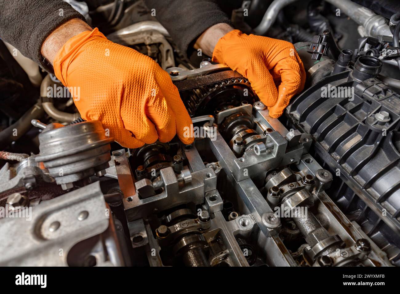 Experience the precision of a skilled mechanic's hands, clad in orange ...