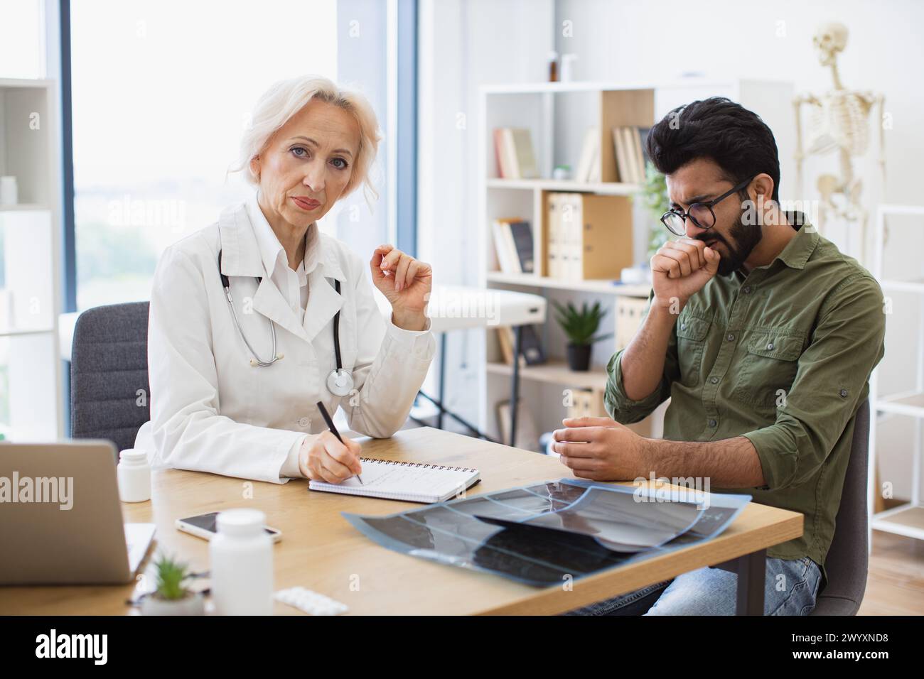 Doctor discussing health issues and prescribes medication for treatment ...