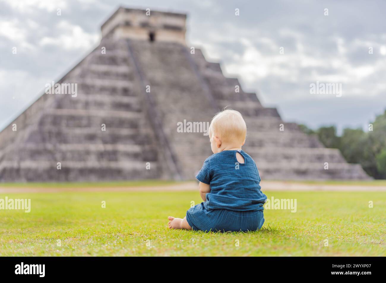 Baby traveler, tourists observing the old pyramid and temple of the ...