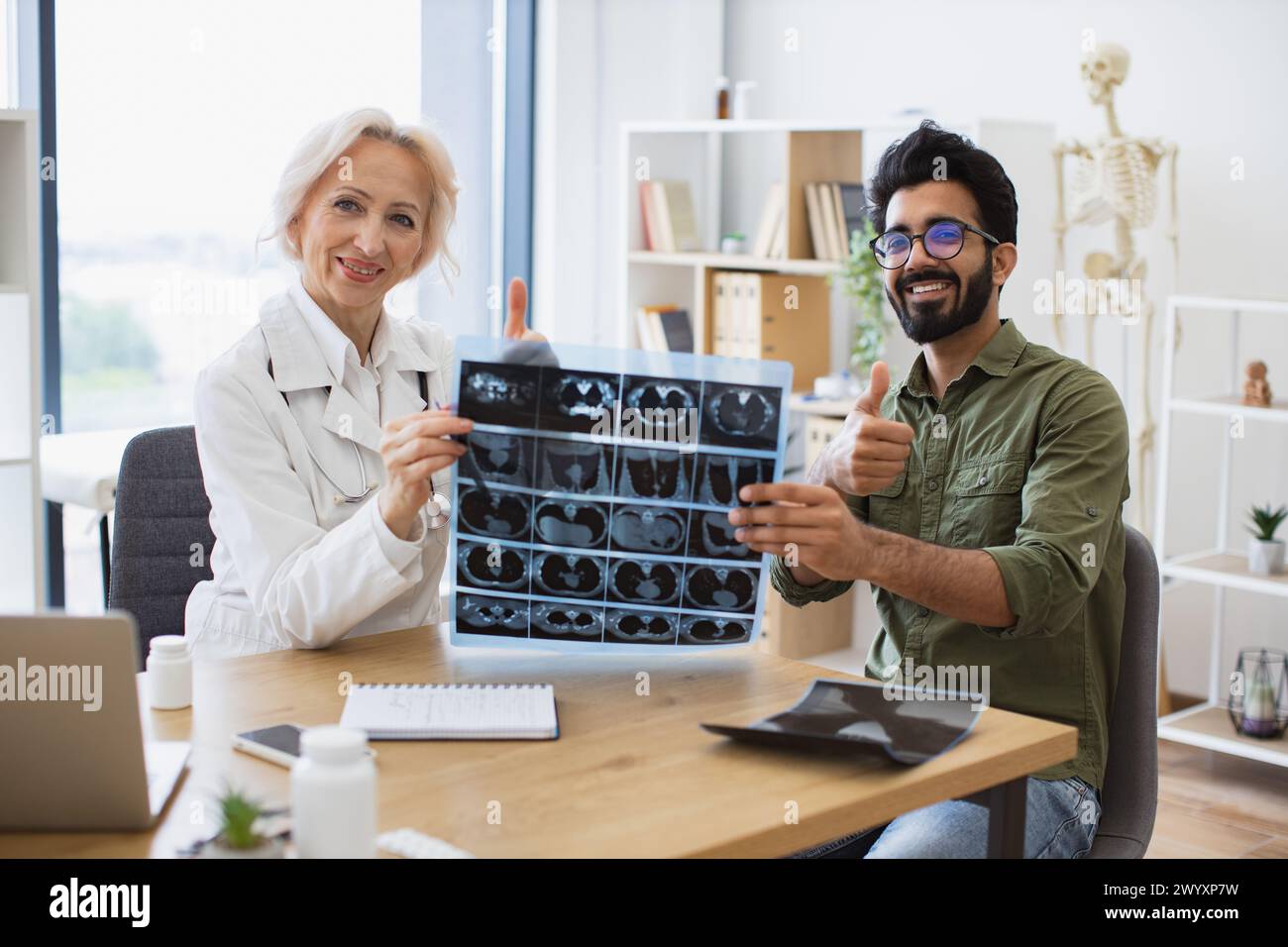 Smiling Senior professional and happy lady posing with CT scan picture ...
