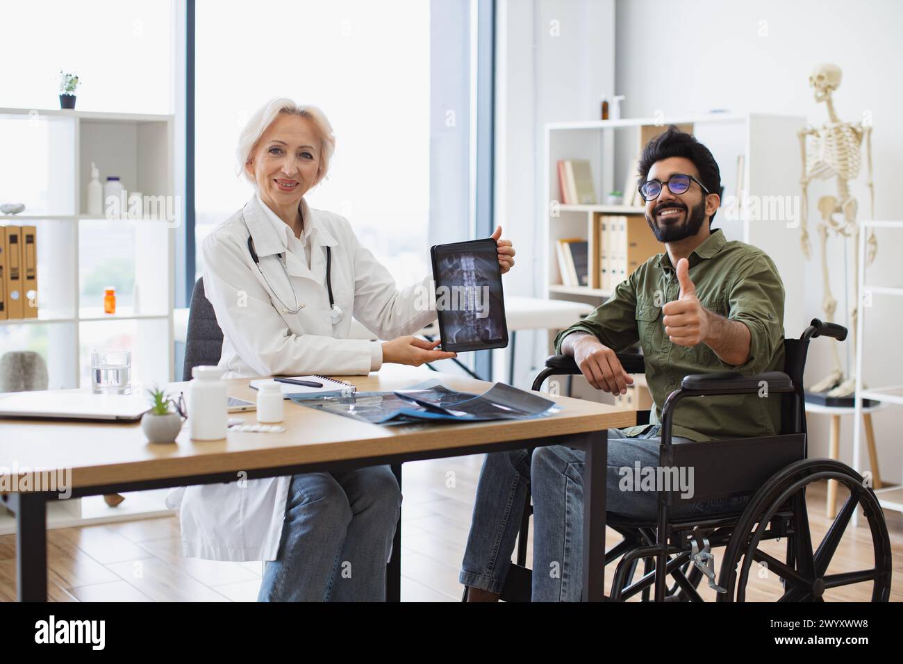 Senior female doctor and bearded male patient with disability Stock ...