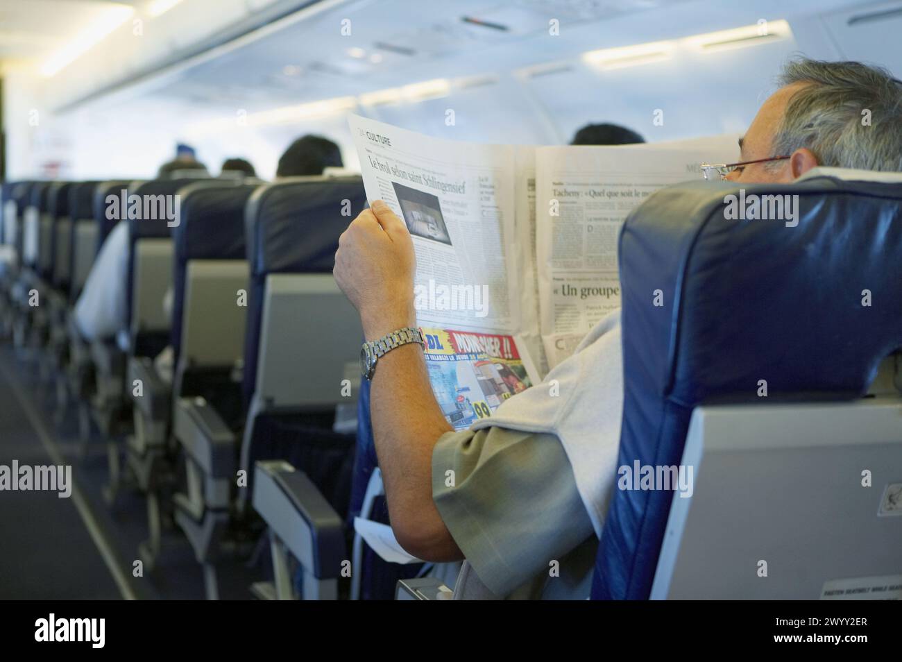 Reading newspaper during flight Stock Photo - Alamy