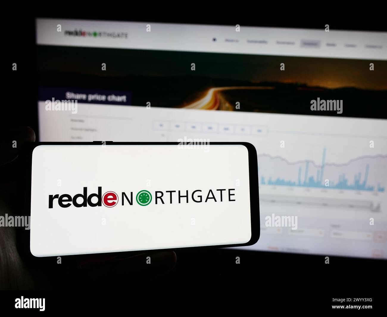 Person holding mobile phone with logo of British vehicle rental company ...