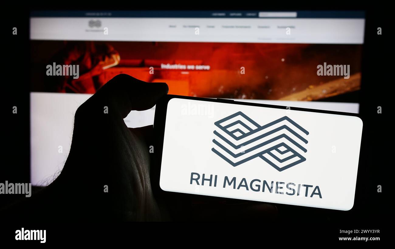 Person holding mobile phone with logo of refractory products company ...