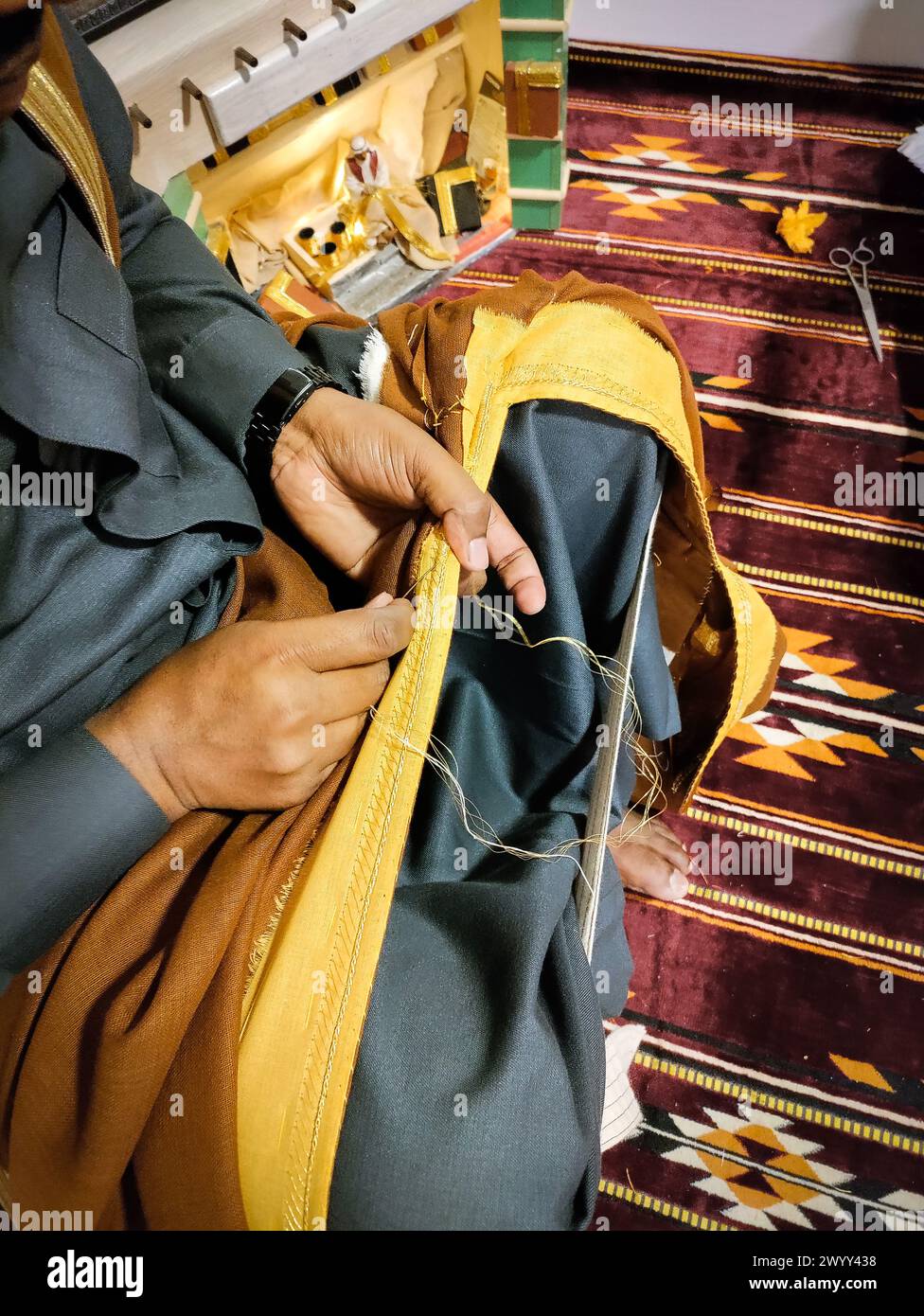 Close up shot of how the tailor are making a bisht, in Arabic cloak for ...