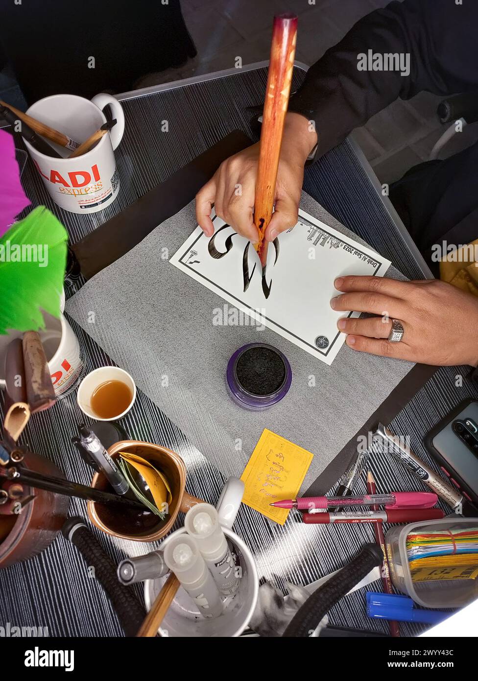 A younger boy draw Arabic calligraphy, close up Muslim boy hands ...