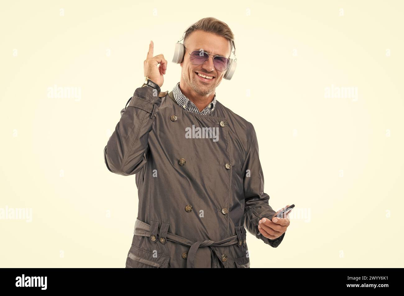Happy man listening to music pointing finger up. Music player in ...