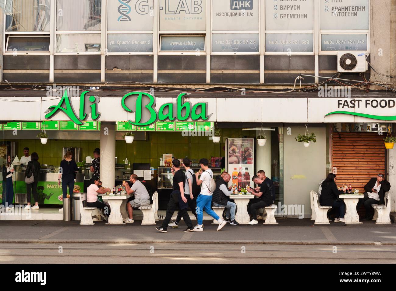 Ali Baba fast food doner kebab shop and customers at outdoor tables ...