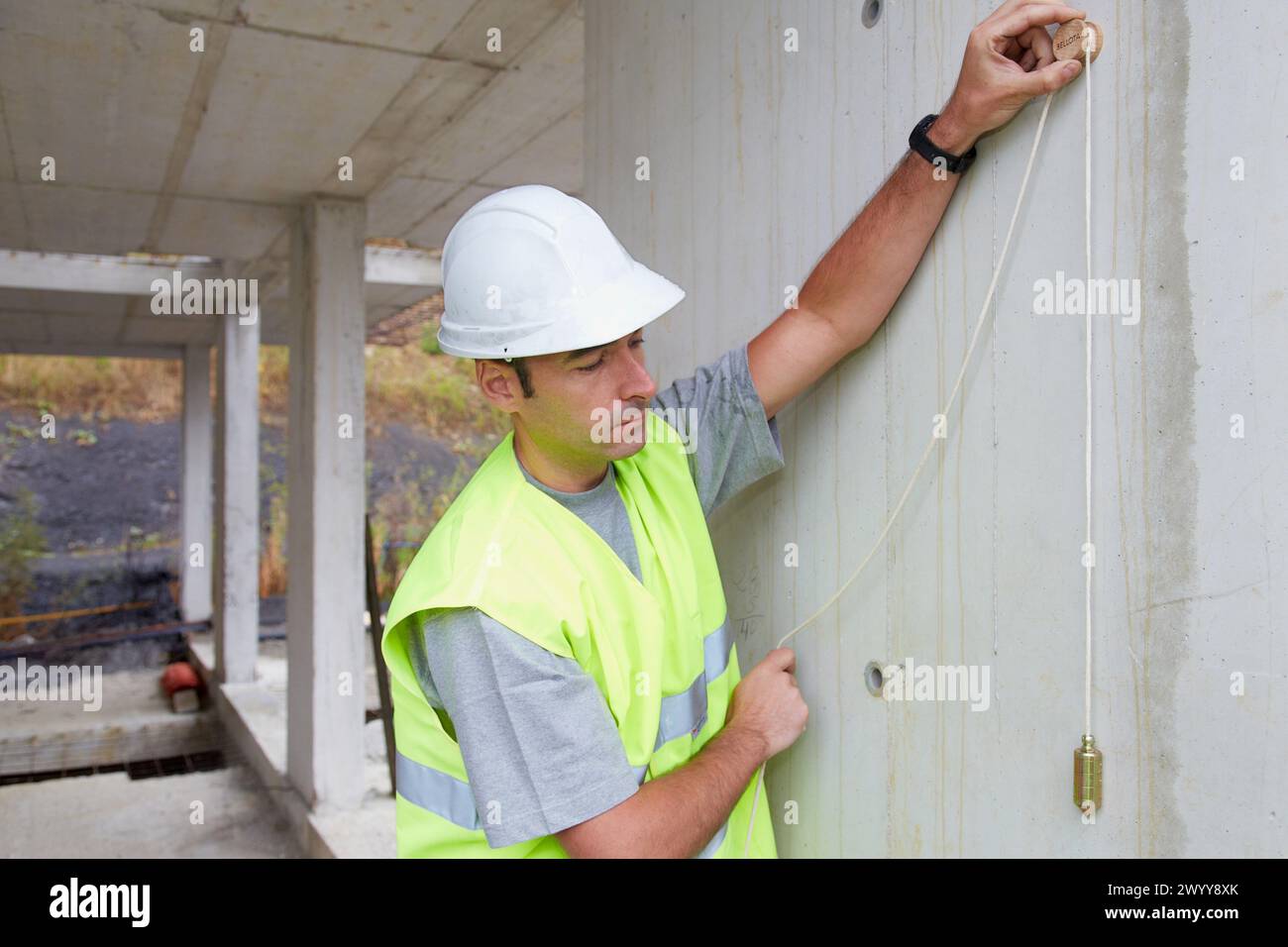 Worker with protective equipment, PPE, Checking and aligning vertical ...