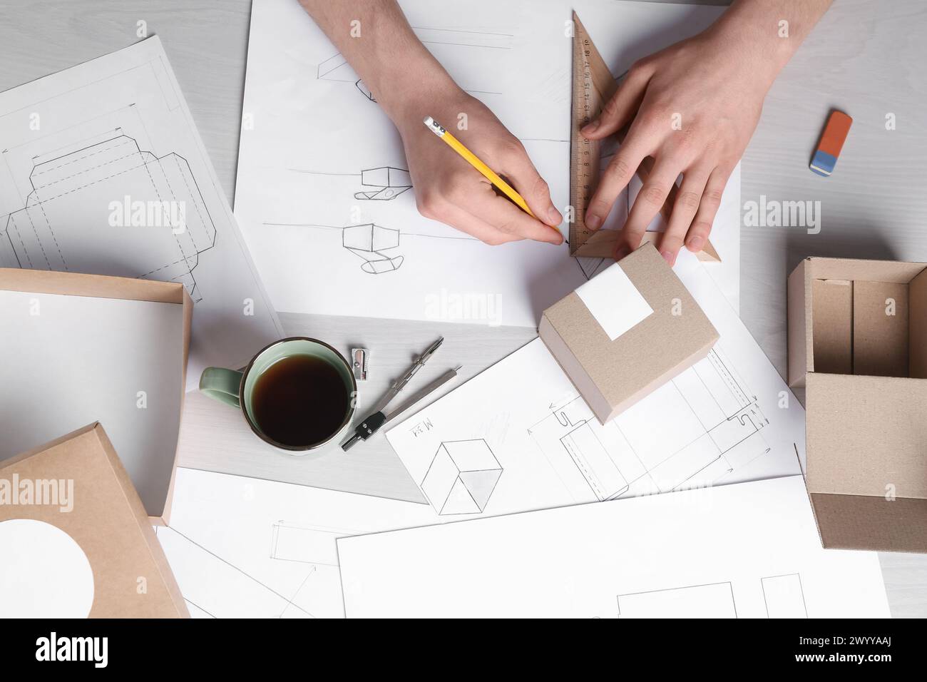 Man creating packaging design at light wooden table, top view Stock ...