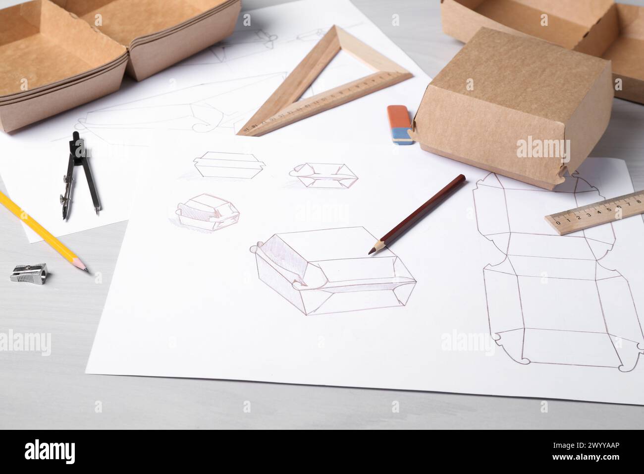 Creating packaging design. Drawings, boxes and stationery on light ...
