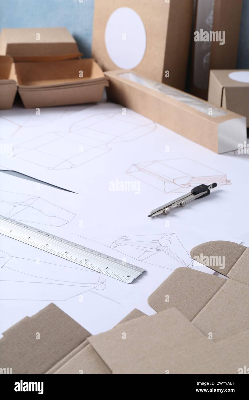 Creating packaging design. Drawings, boxes and stationery on table ...
