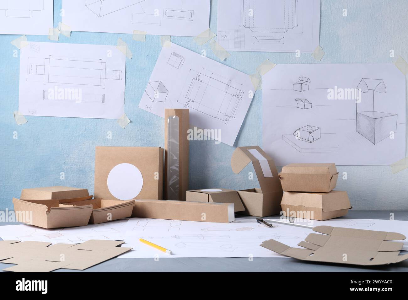 Creating packaging design. Drawings, boxes and stationery on table ...