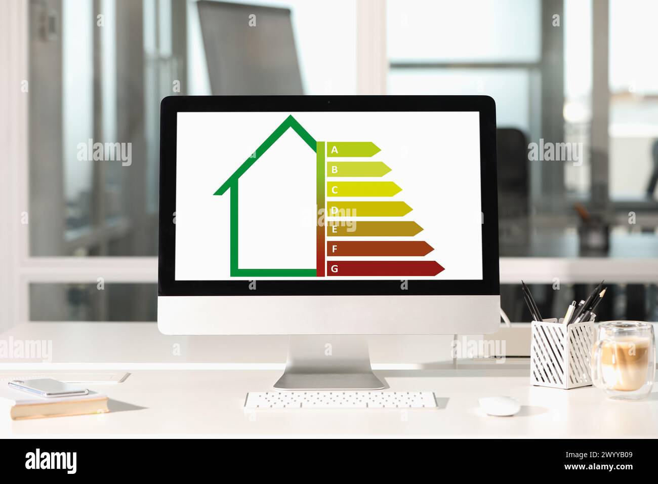Energy efficiency rating on display. Workplace with modern computer ...