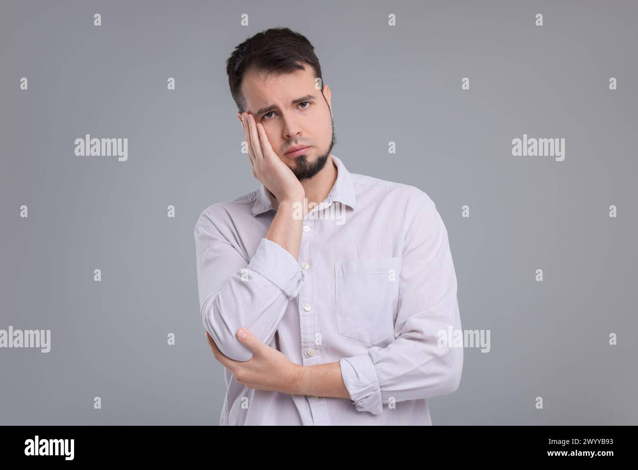 Portrait of sad man on grey background Stock Photo - Alamy