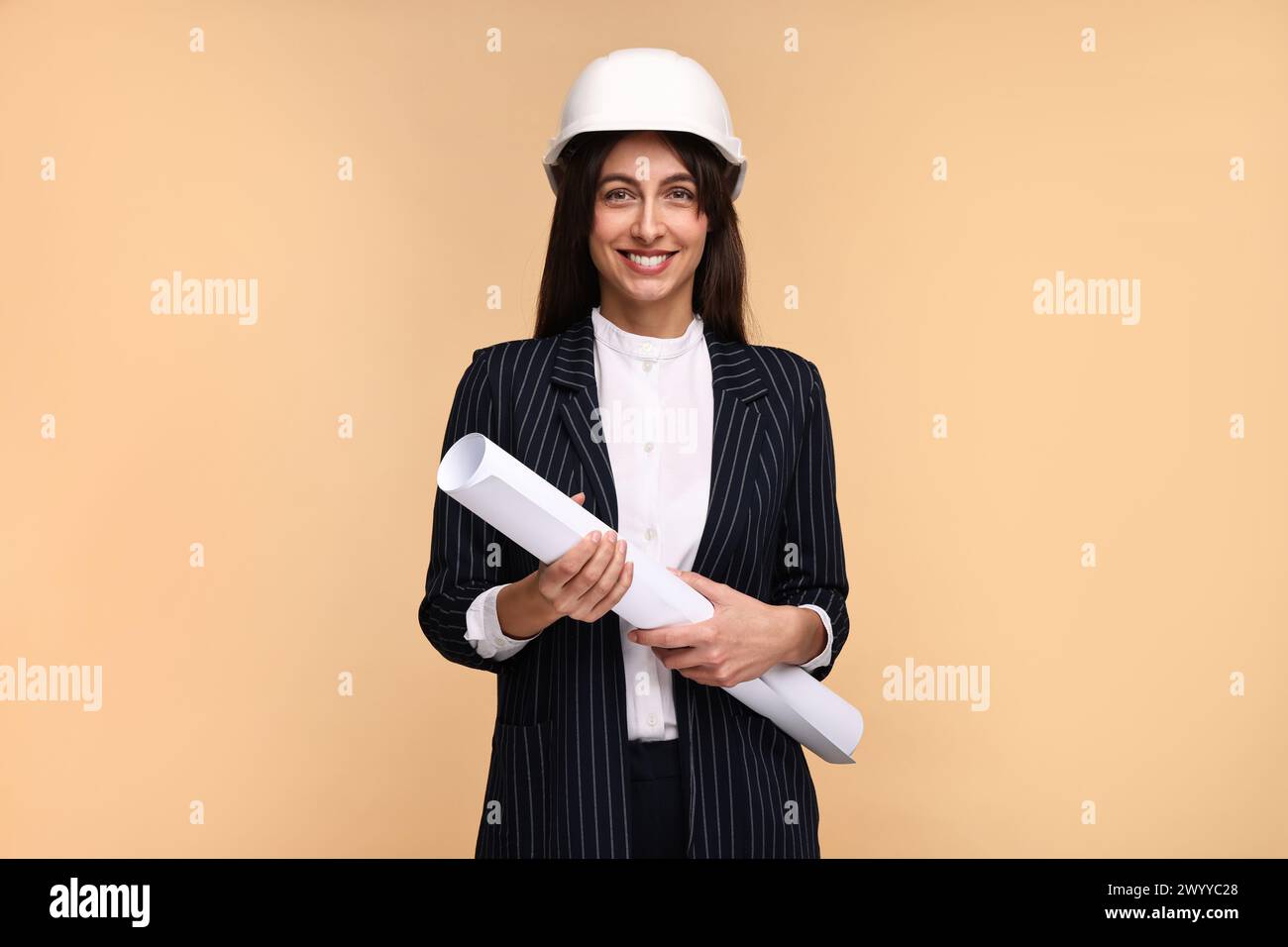 Architect in hard hat with draft on beige background Stock Photo - Alamy