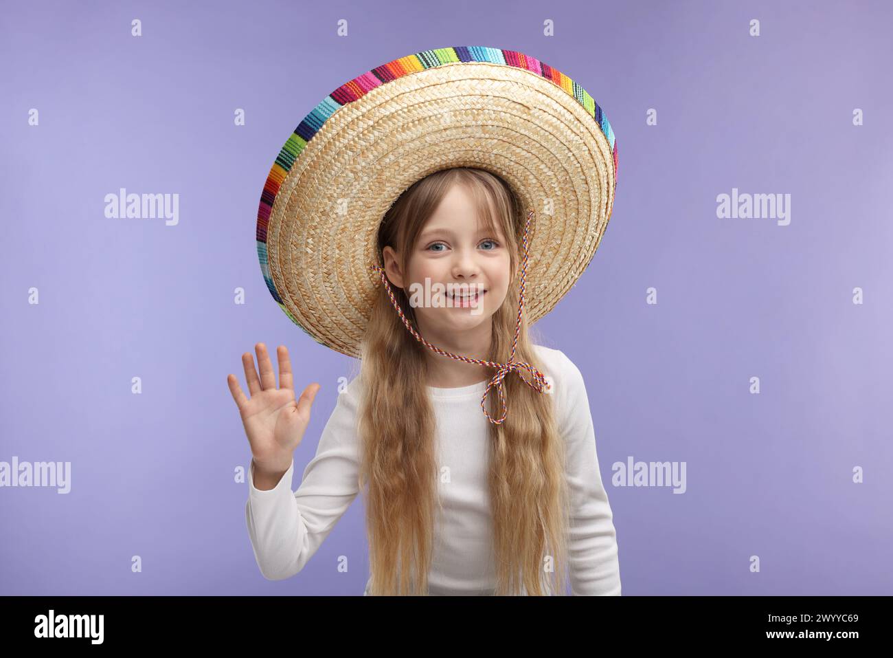 Cute girl in Mexican sombrero hat waving hello on purple background ...