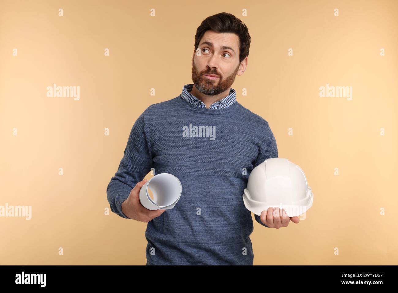 Architect with hard hat and draft on beige background Stock Photo - Alamy