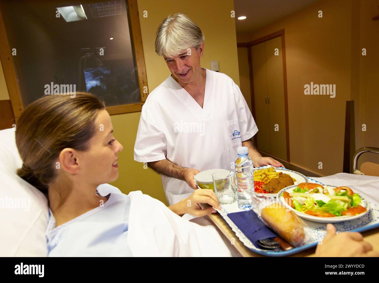 Nurse with food tray and patient in a hospital room. Hospital ...