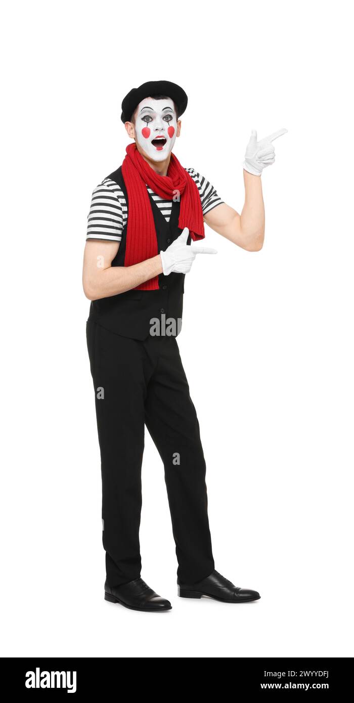 Funny mime artist in beret pointing at something on white background ...