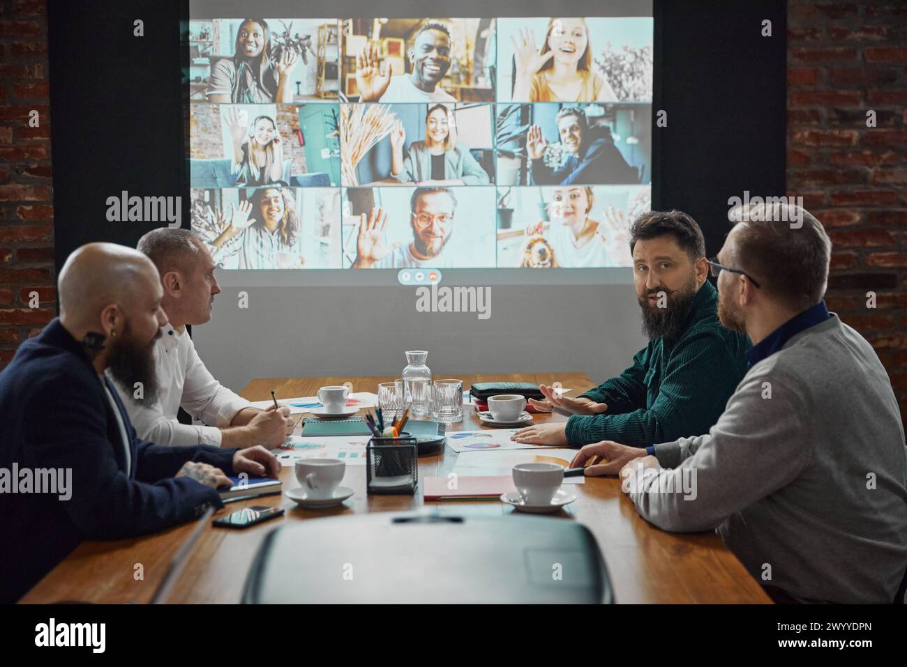 Team leaders gathering in conference room, having online video call to ...