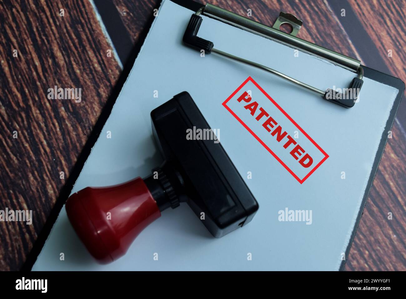 Red Handle Rubber Stamper and Patented text above paperwork isolated on ...