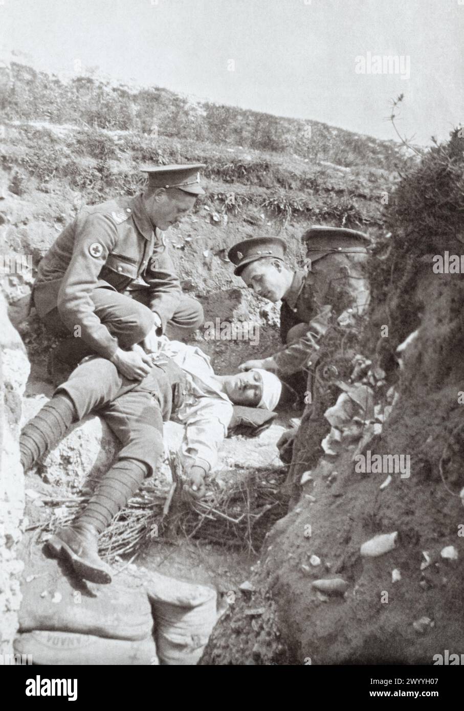 Stretcher bearers of the Royal Army Medical Corps attending to a wounded soldier in a trench ...