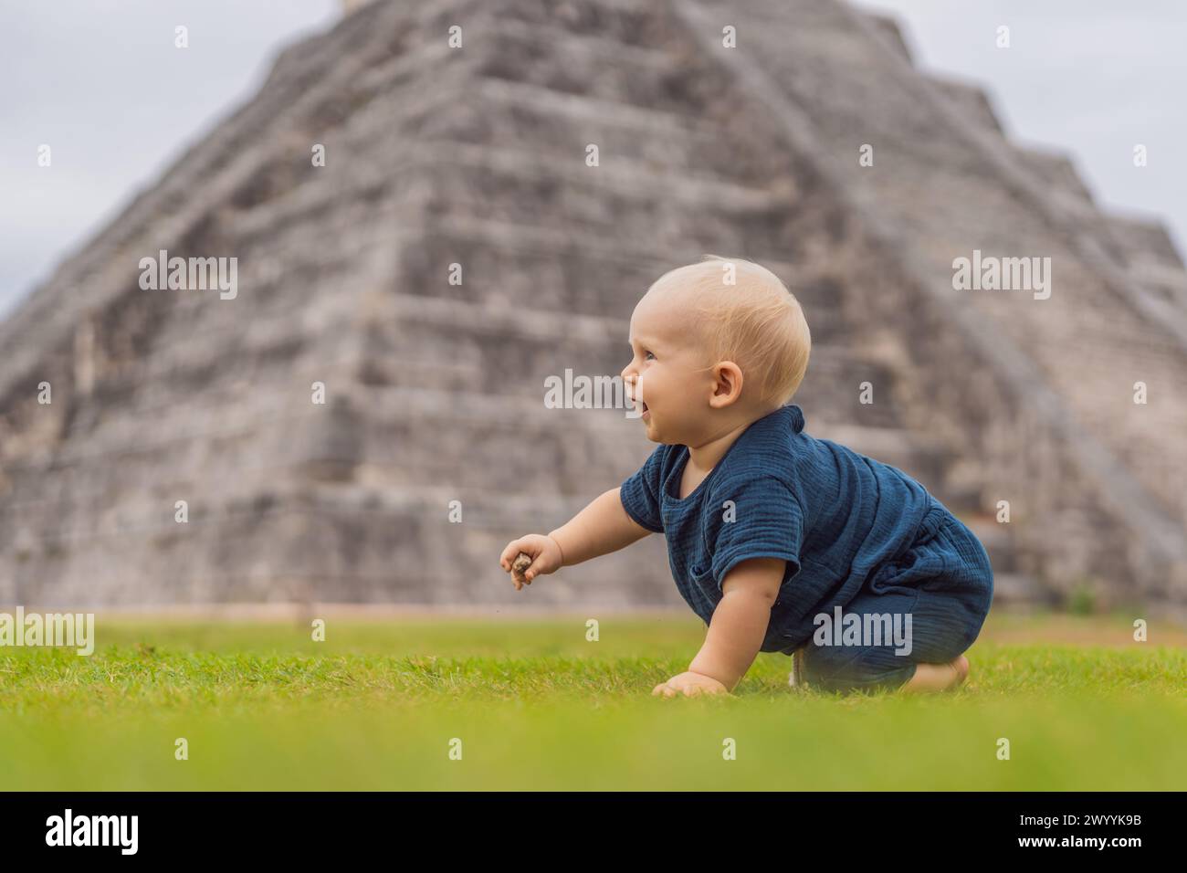 Baby traveler, tourists observing the old pyramid and temple of the ...