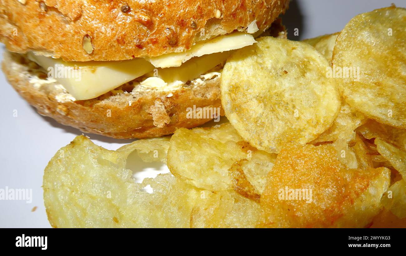 A seedy brown cheese roll and some crisps Stock Photo - Alamy