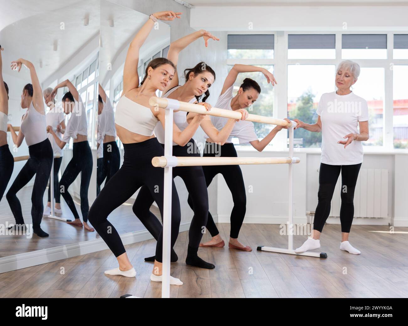 Teacher conducts class with girls in ballet studio, observes doing ...