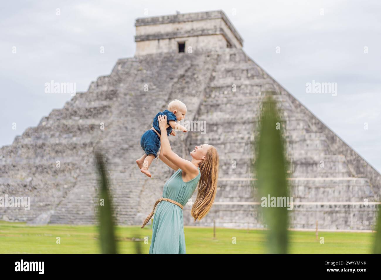 Beautiful tourist woman and her son baby observing the old pyramid and ...
