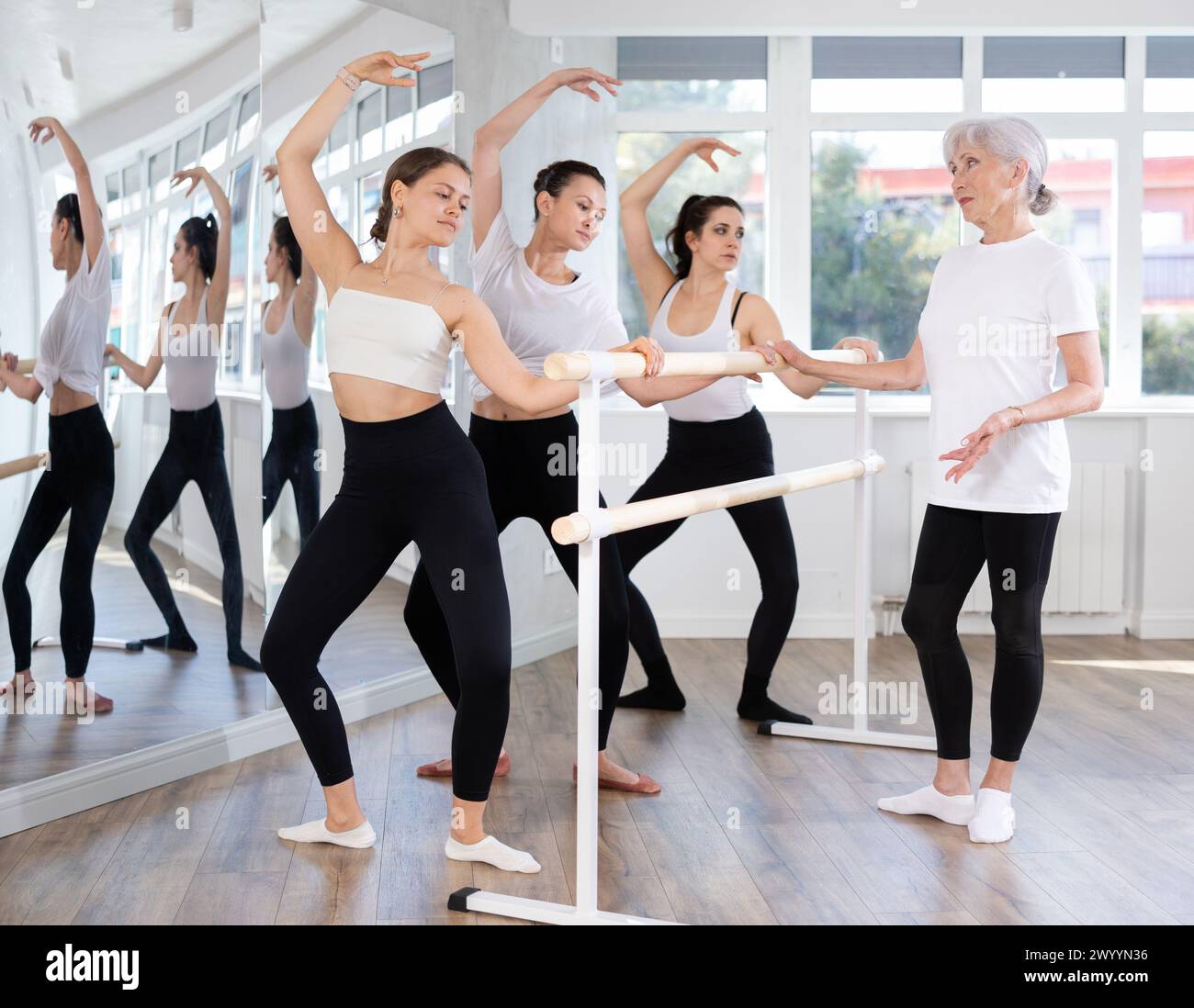 Teacher conducts class with girls in ballet studio, observes doing ...