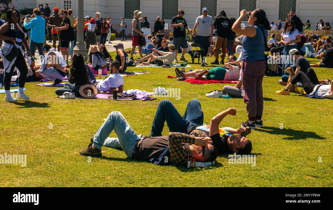 People lying on their backs on the lawn watching the 2024 solar eclipse ...
