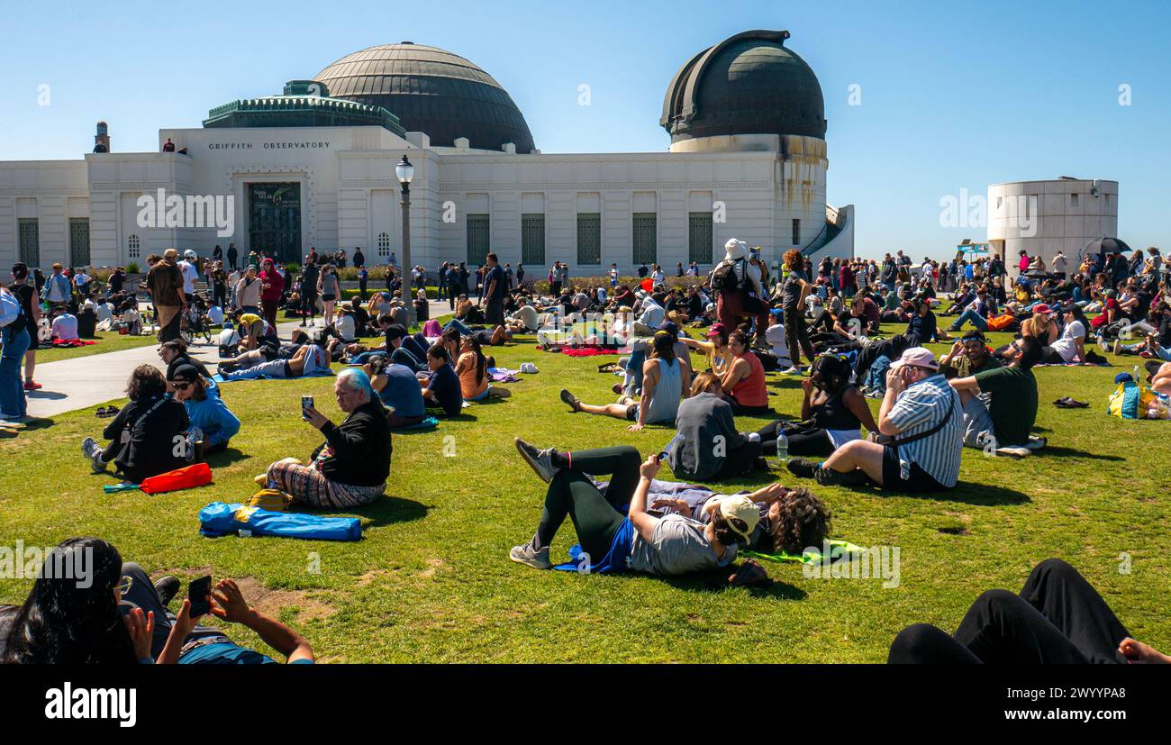 A crowd of people watching the 2024 solar eclipse in front of Griffith ...