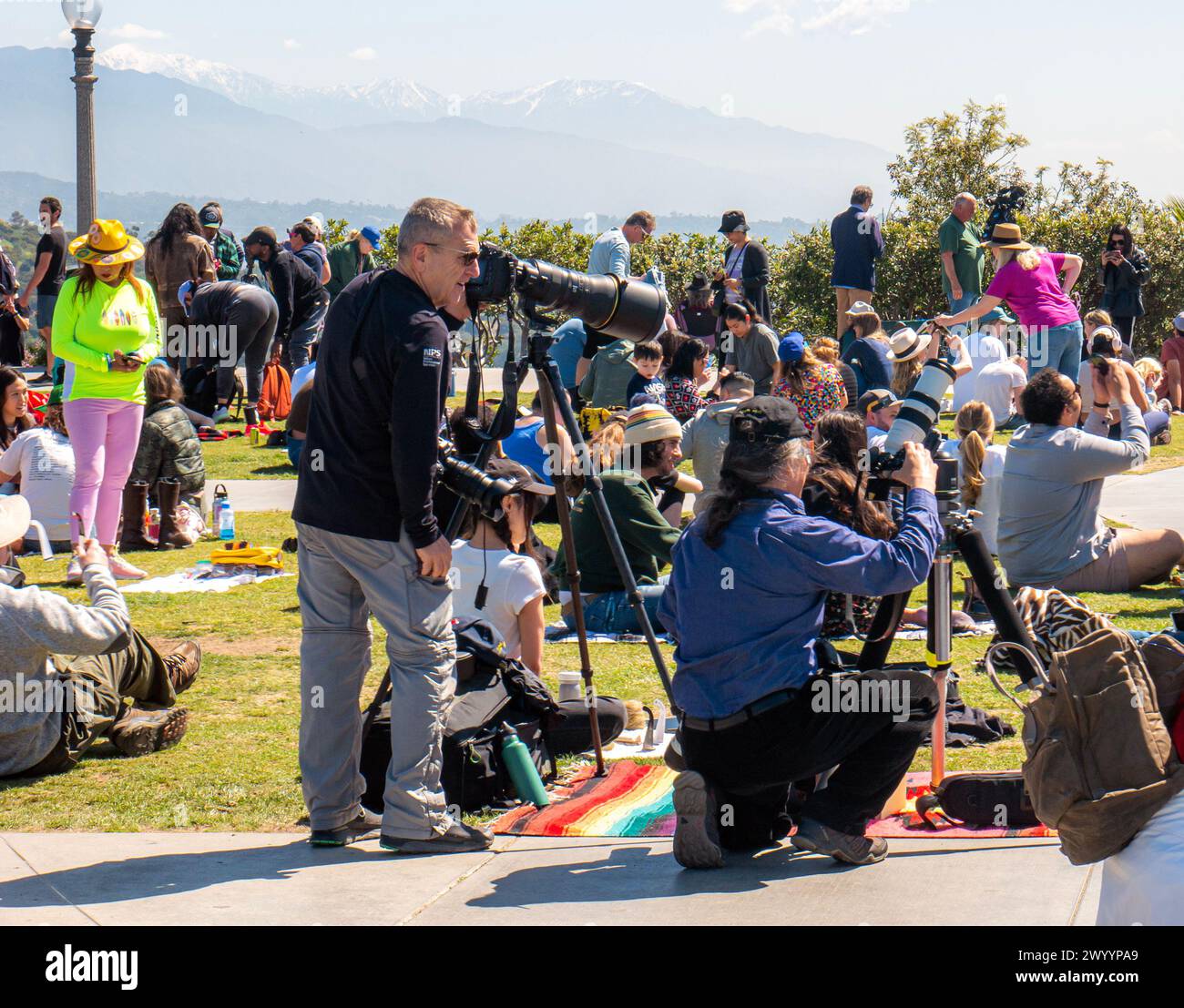 Two men with cameras and telescopes with solar filters watching the ...