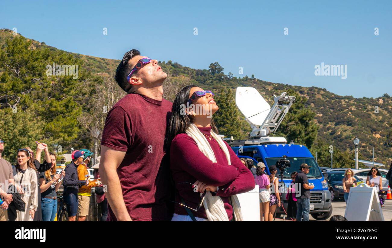 A man and a woman watching the 2024 solar eclipse in Griffith Park, Los ...