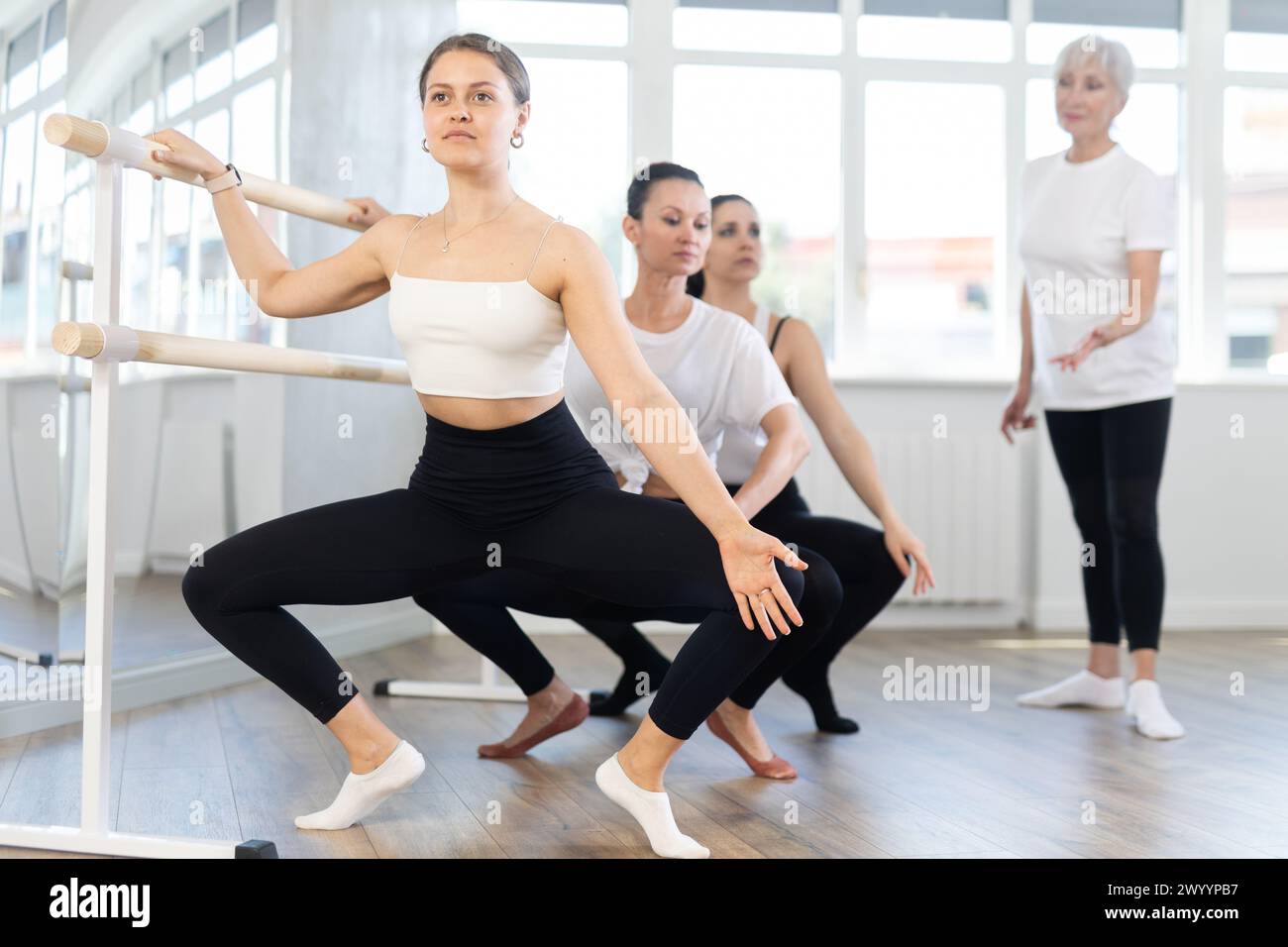 Young female ballet dancer practicing grand plie at barre Stock Photo ...
