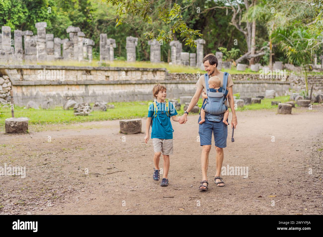 Father and two sons tourists observing the old pyramid and temple of ...