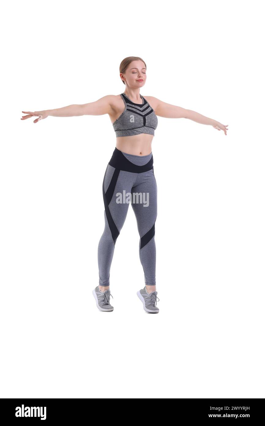Sporty young woman balancing on white background Stock Photo - Alamy