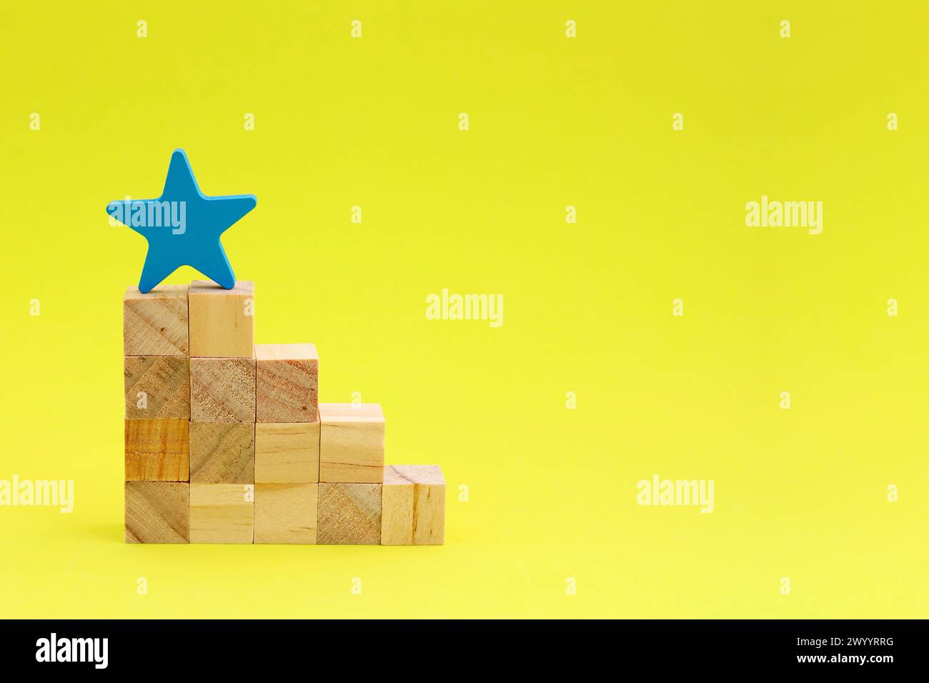 Star reaching a goal at the top of ladder made with wooden cubes Stock ...