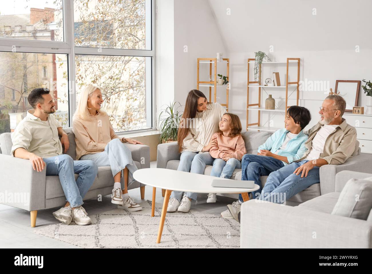 Big family sitting on sofas at home Stock Photo - Alamy