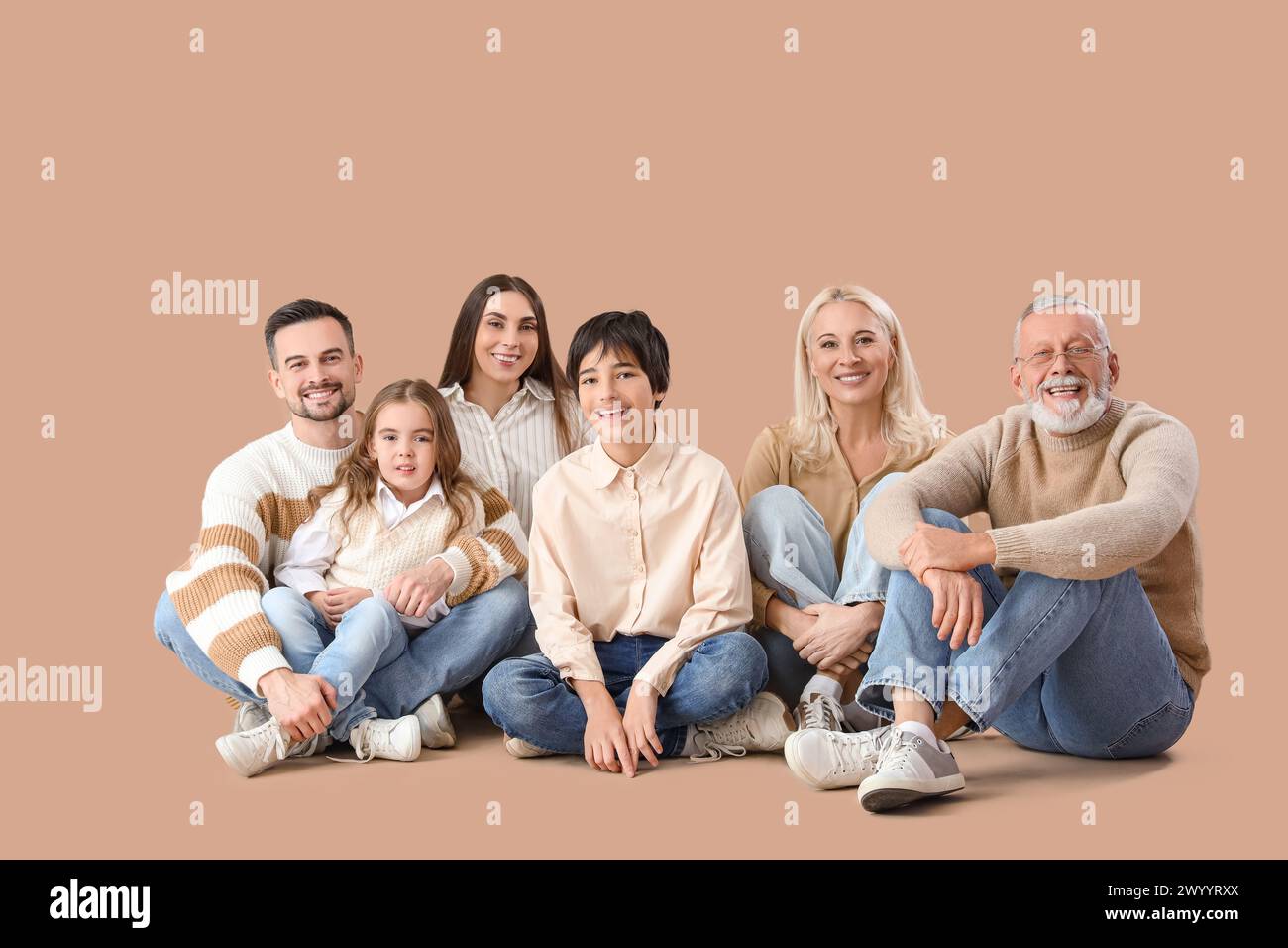Big family sitting on beige background Stock Photo - Alamy