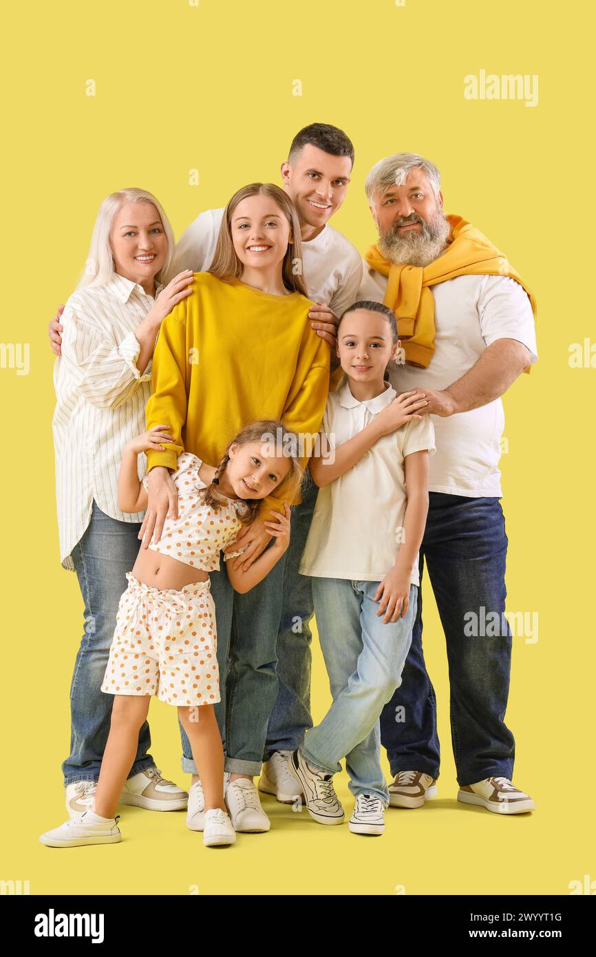 Big family hugging on yellow background Stock Photo - Alamy